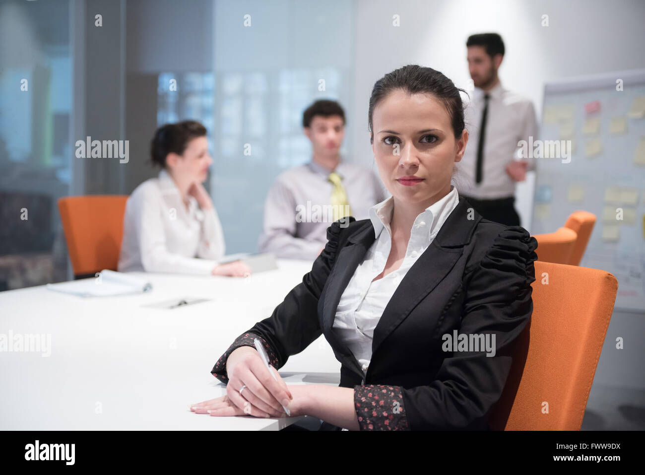 young business woman on meeting usineg laptop computer, blured group of ...