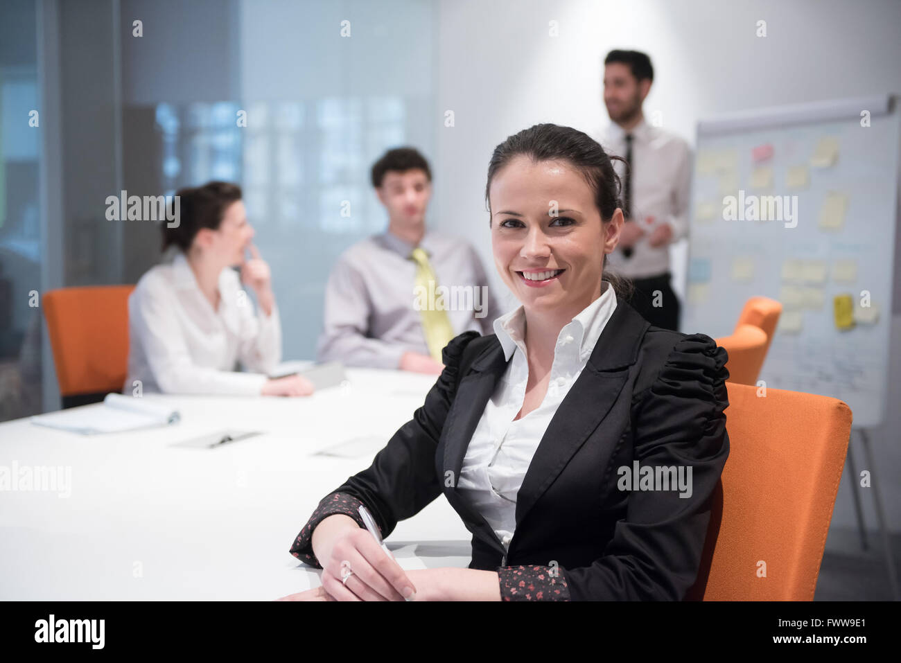 young business woman on meeting usineg laptop computer, blured group of ...