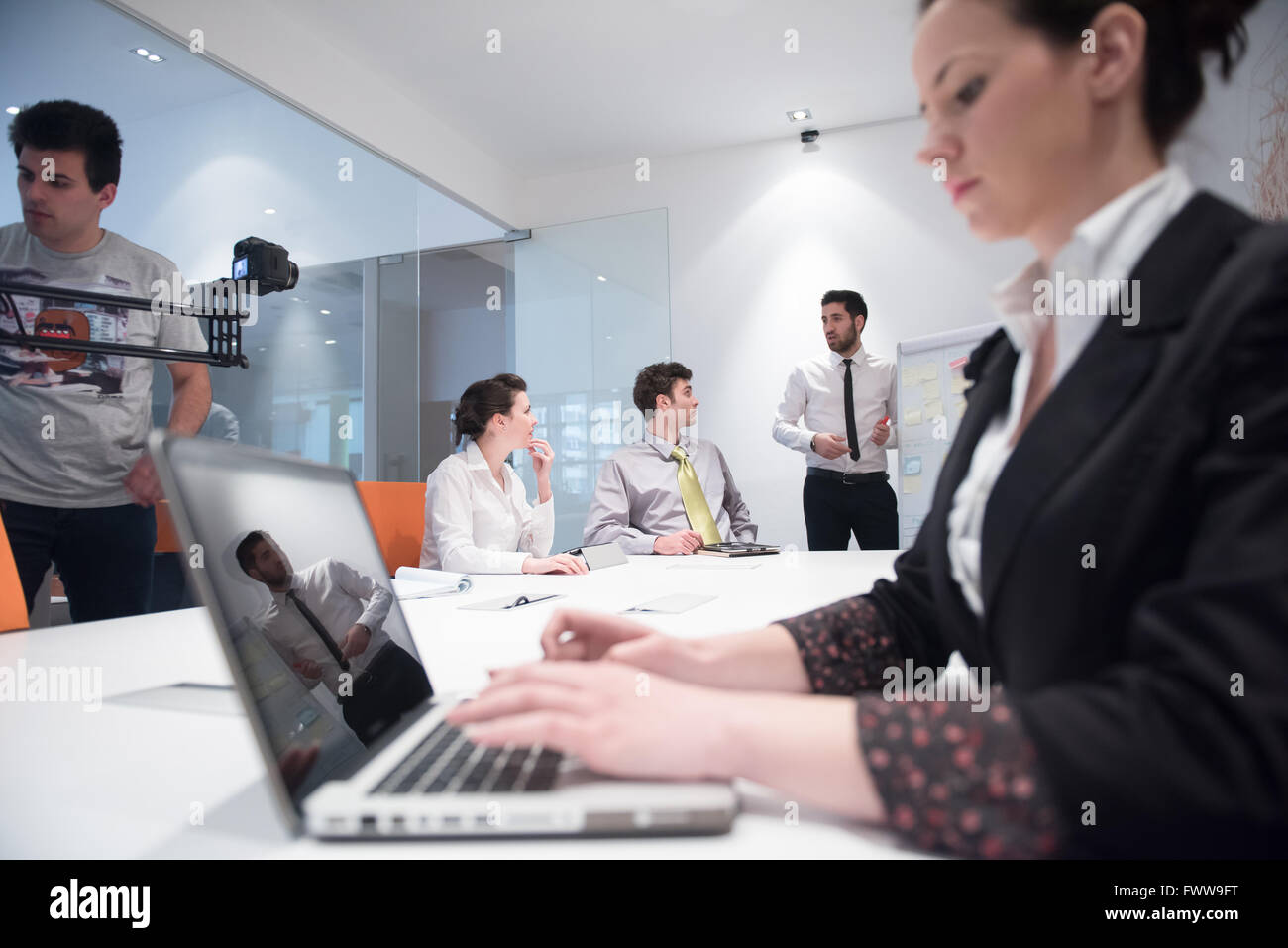 young business woman on meeting usineg laptop computer, blured group of ...