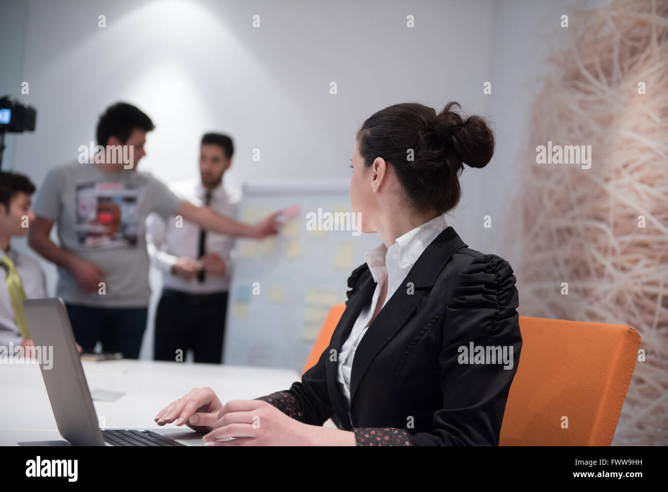 young business woman on meeting usineg laptop computer, blured group of ...
