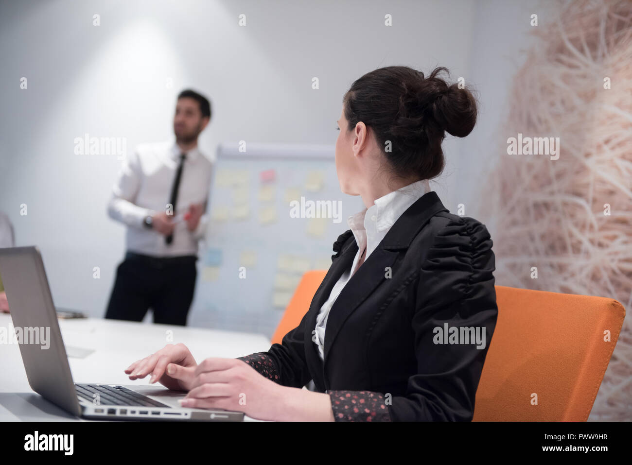 young business woman on meeting usineg laptop computer, blured group of ...