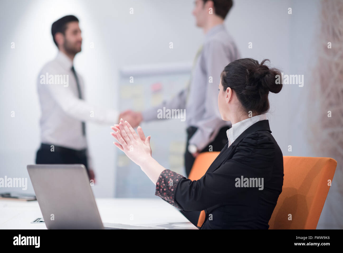 young business woman on meeting usineg laptop computer, blured group of ...