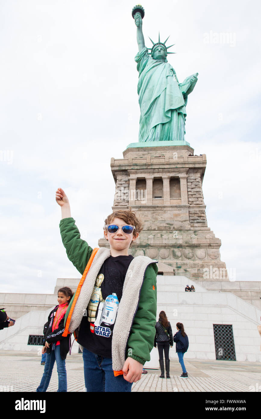 Six year old boy standing in front of the Statue of Liberty, New York ...