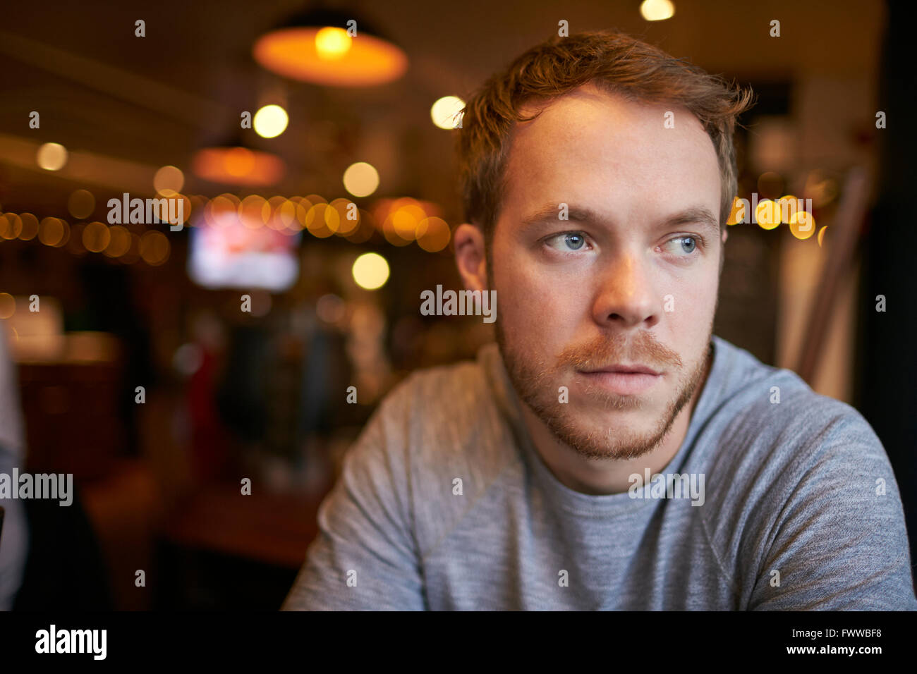 Young Man Sitting Alone In Bar Stock Photo - Alamy