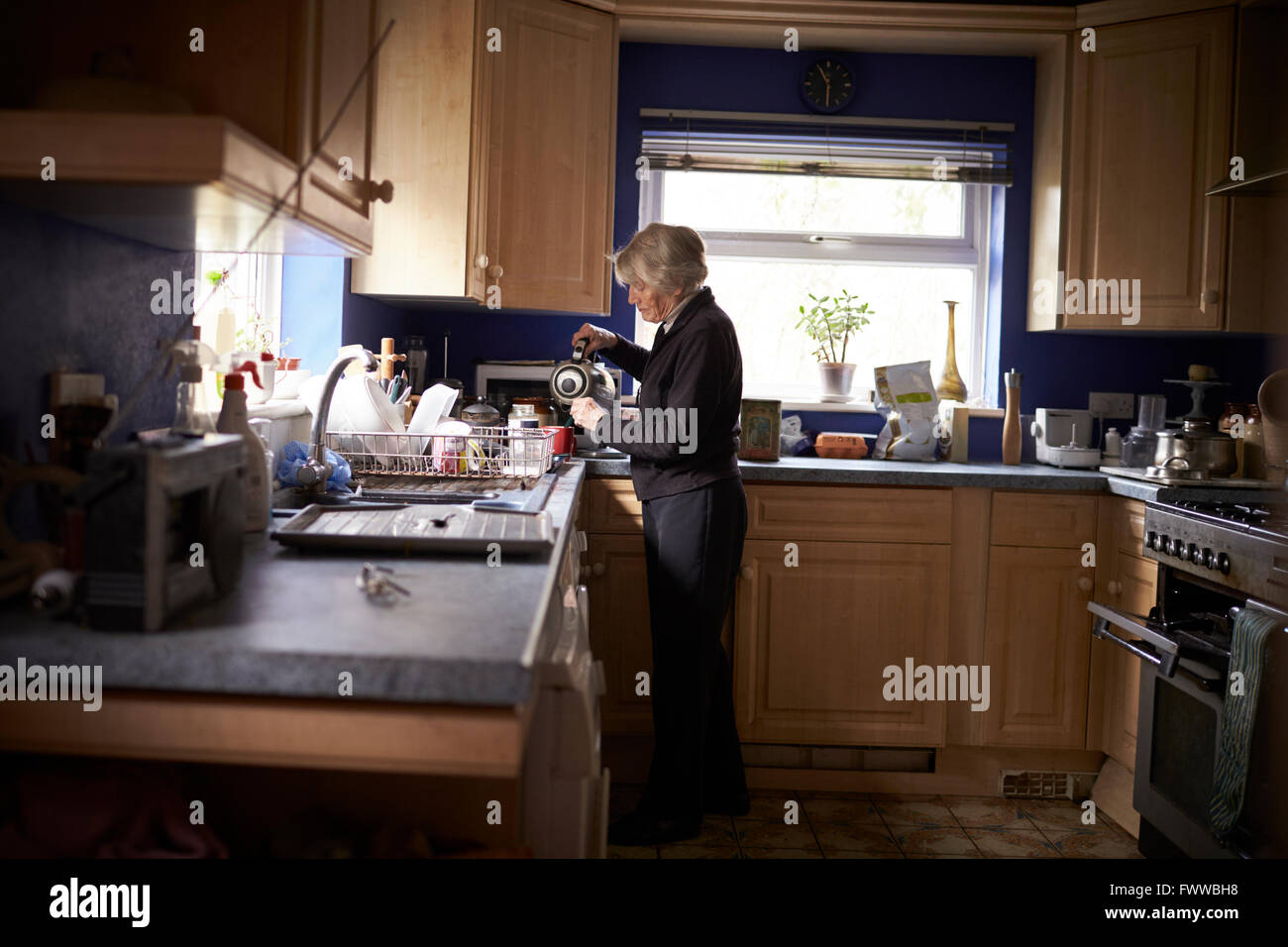 Senior Woman Making Hot Drink In Kitchen Stock Photo - Alamy