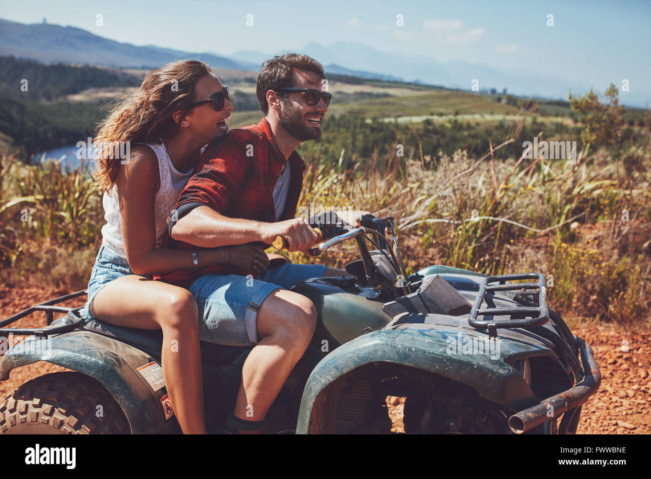 Man and woman having fun on an off road adventure. Couple riding on a ...