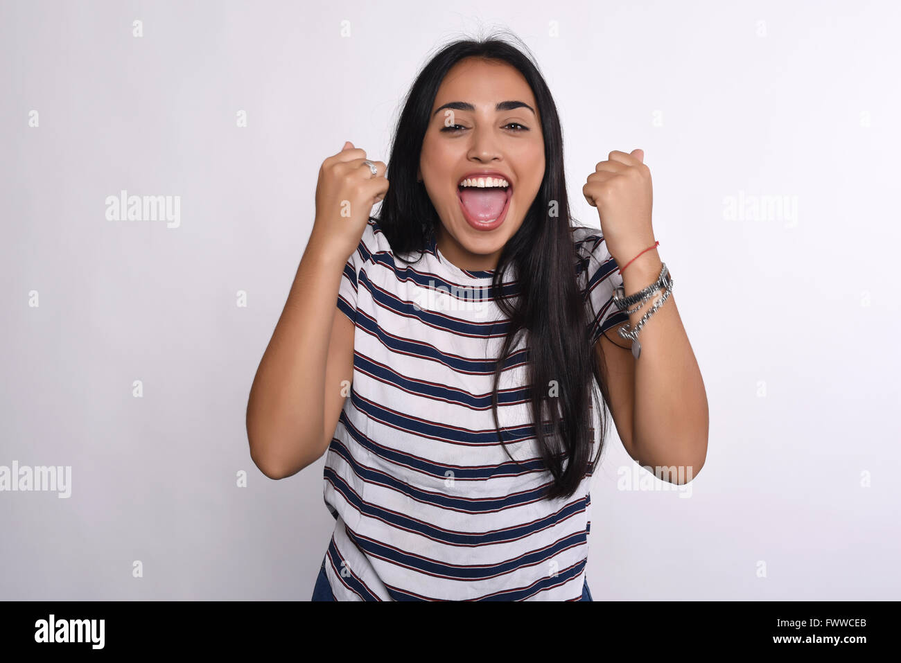 Portrait of young woman celebrating success. Isolated white background ...