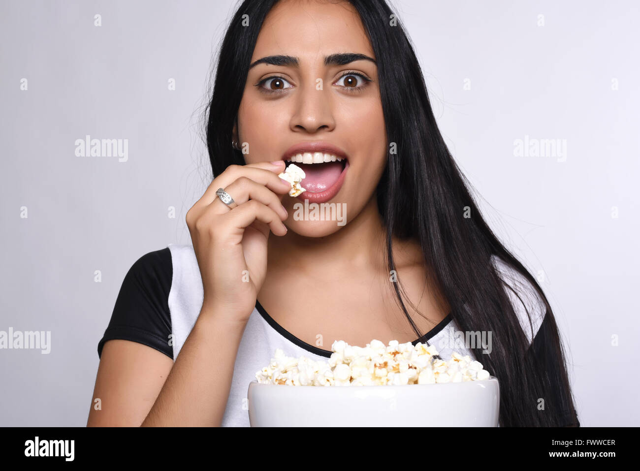 Young beautiful woman eating popcorn. Isolated white background Stock ...