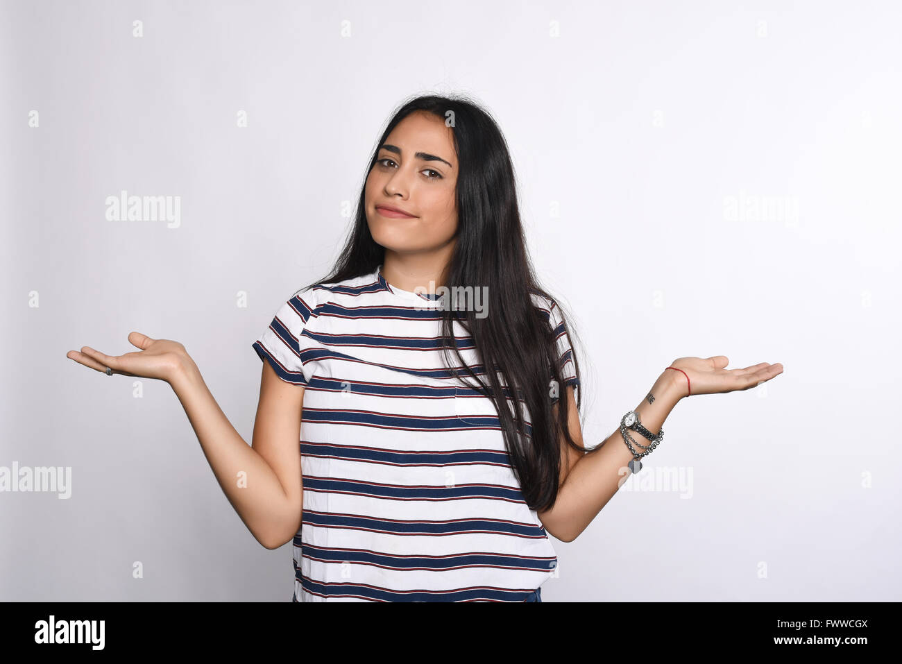 Indecisive young woman with arms open. Isolated white background Stock ...