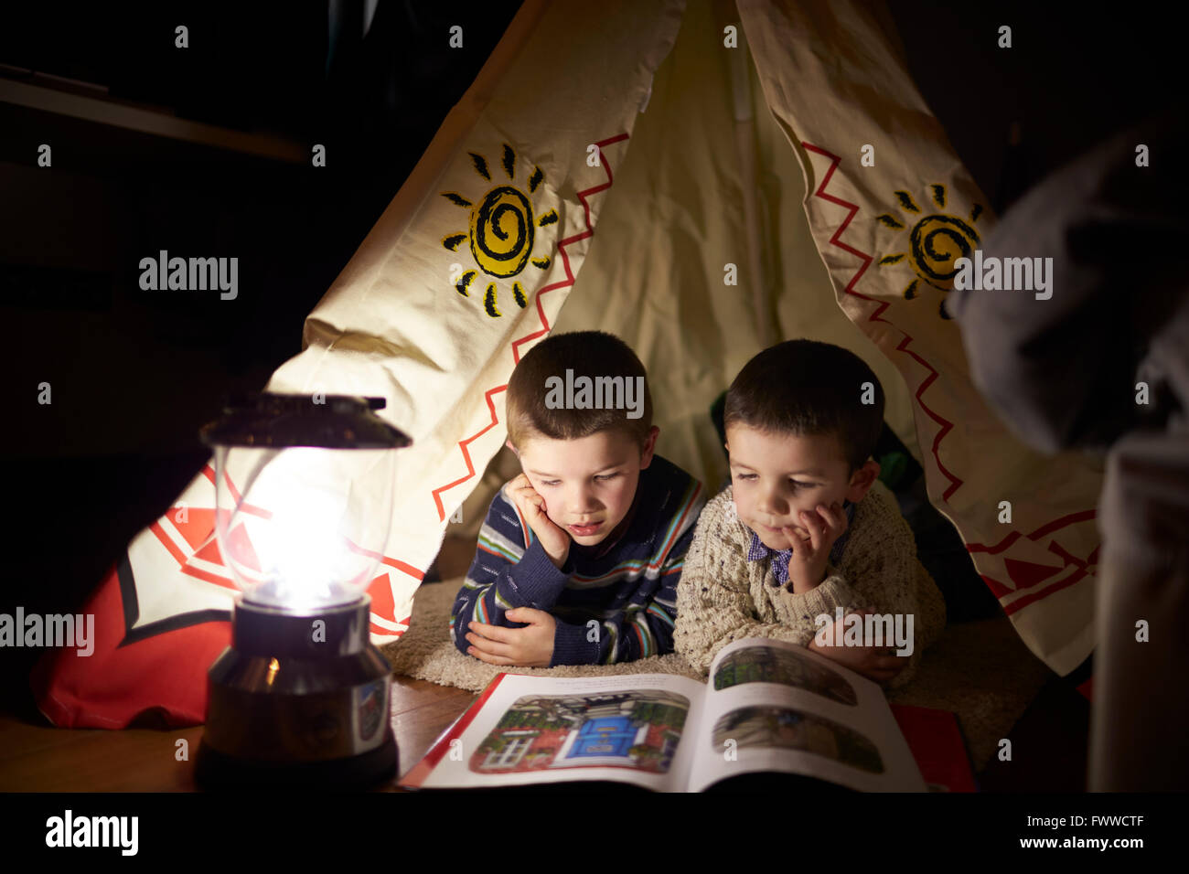 Two Young Boys Reading Inside Tent Set Up Indoors Stock Photo - Alamy