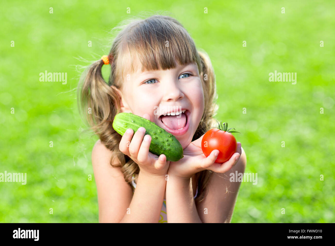 Adorable little girl with vegetables outdoor Stock Photo - Alamy