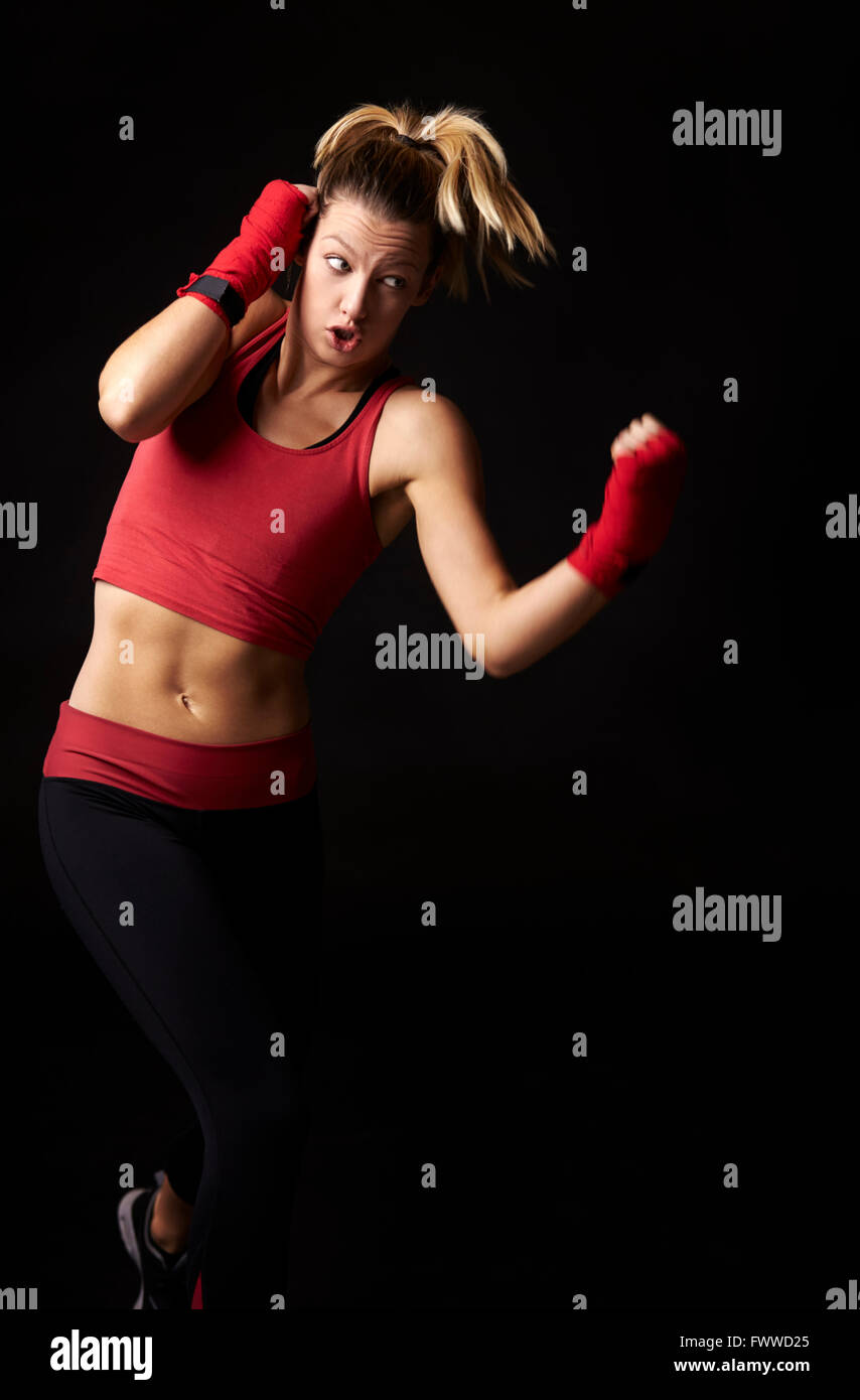 Front view of young woman shadow boxing with fists wrapped Stock Photo ...