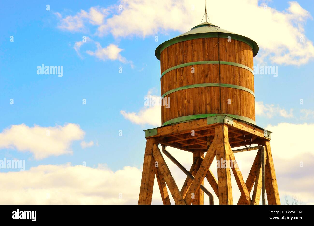 A view of a wooden water tower high in the cloudy blue sky Stock Photo ...