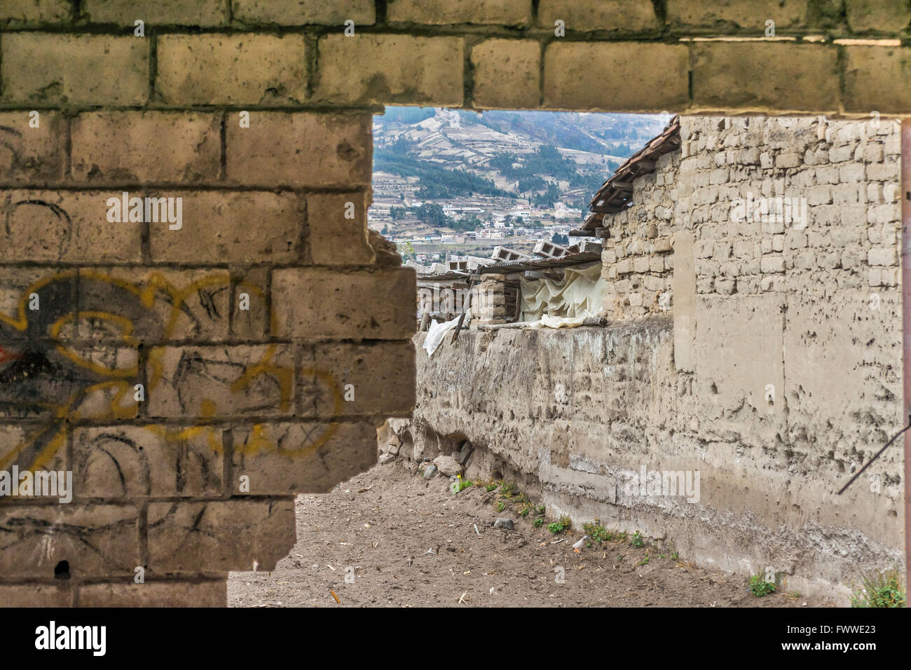 Close up view of broken brick wall and poor houses at background in a ...