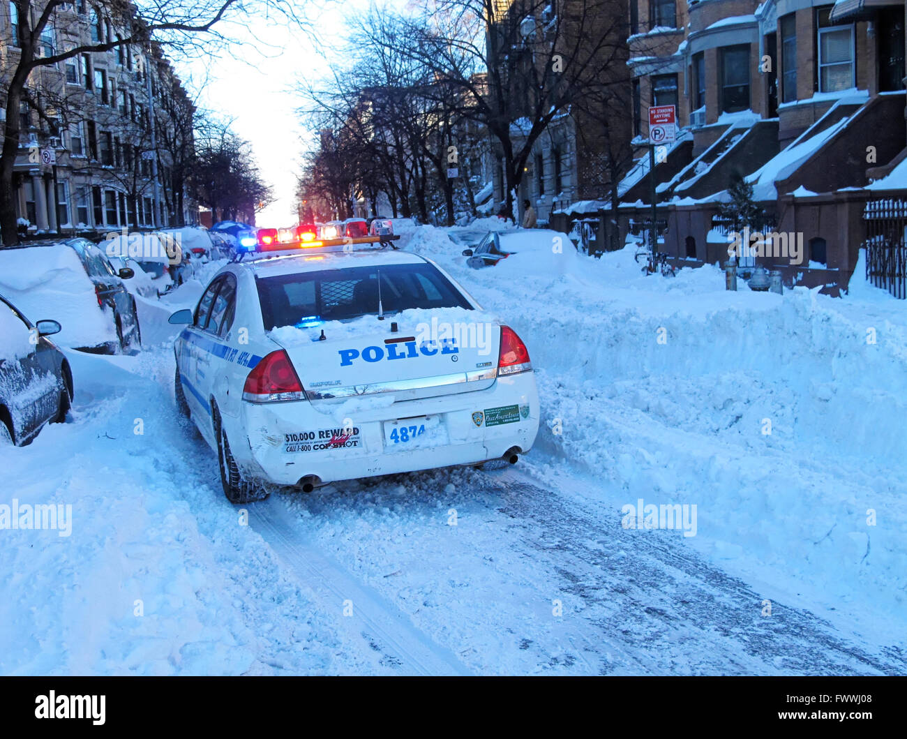 Police cruiser driving through snow covered streets after a snowstorm ...