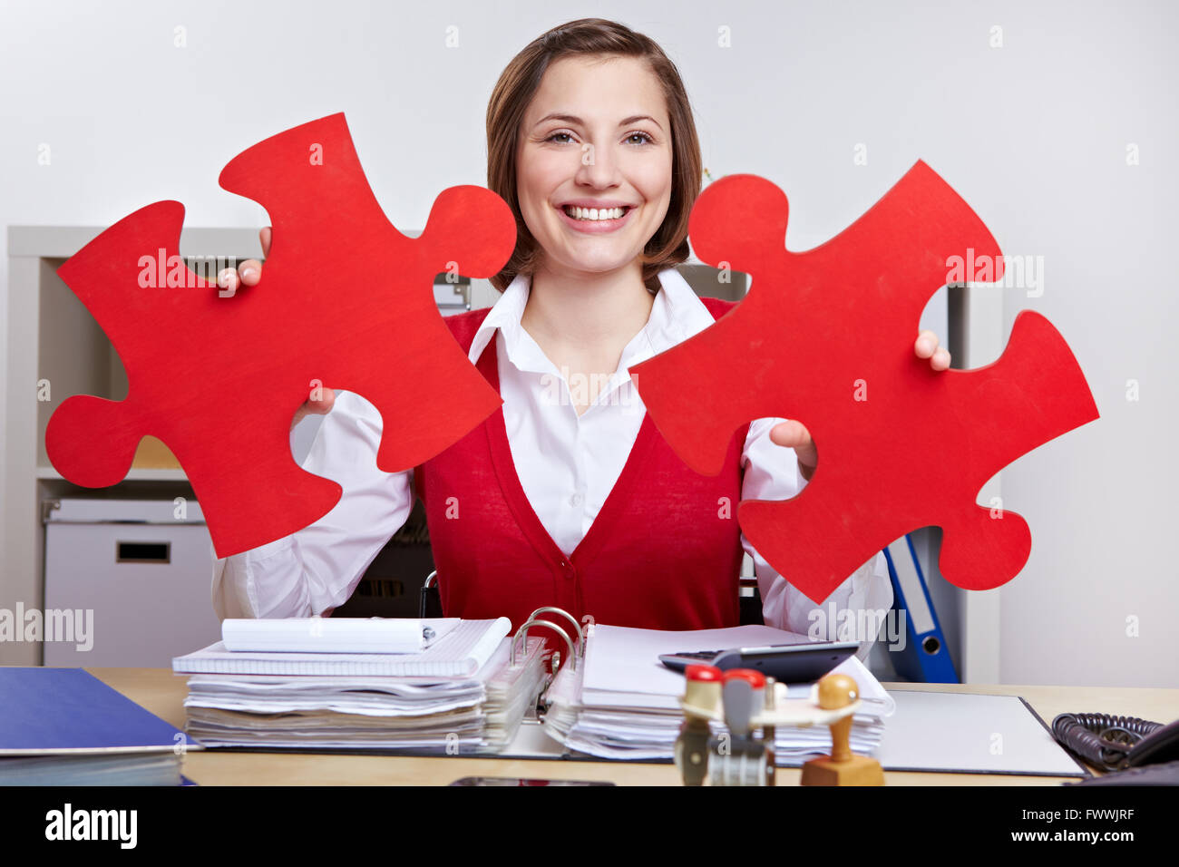 Smiling woman with two oversized red jigsaw puzzle pieces Stock Photo ...