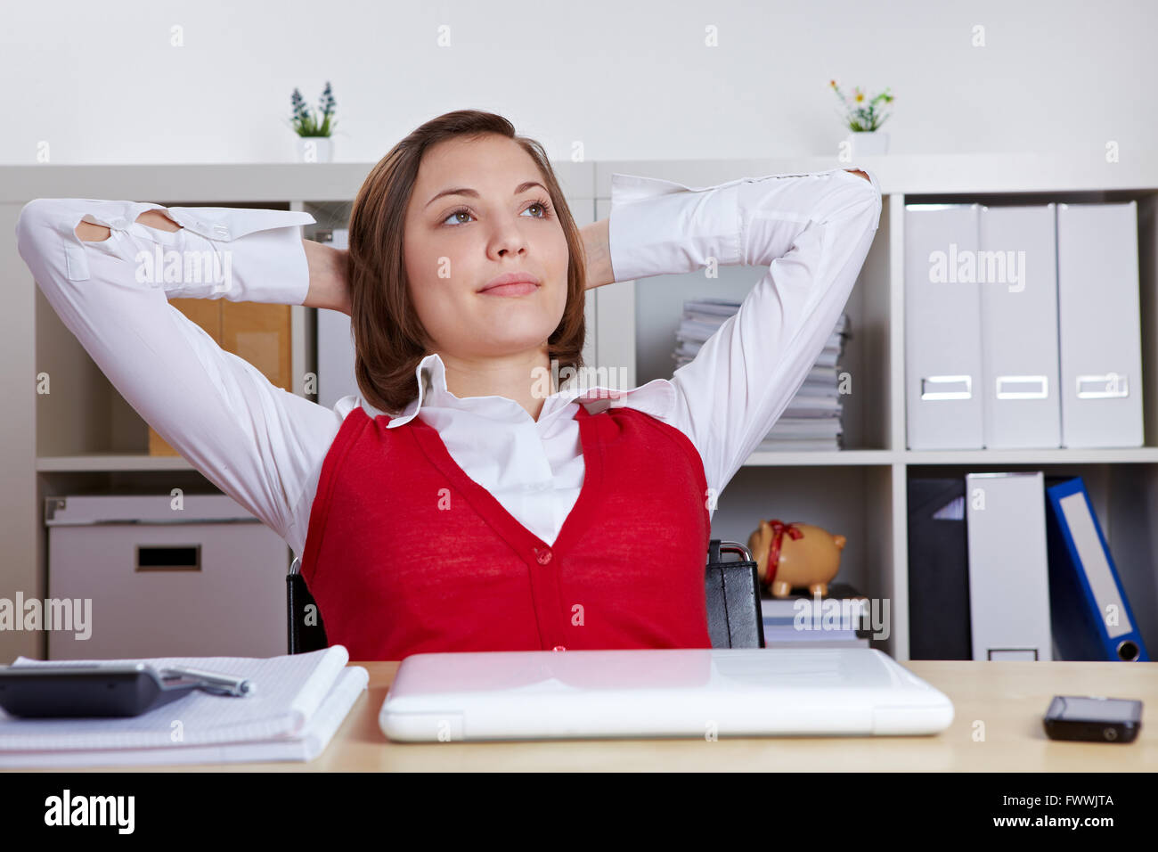 Relaxed female student at her desk leaning back Stock Photo - Alamy