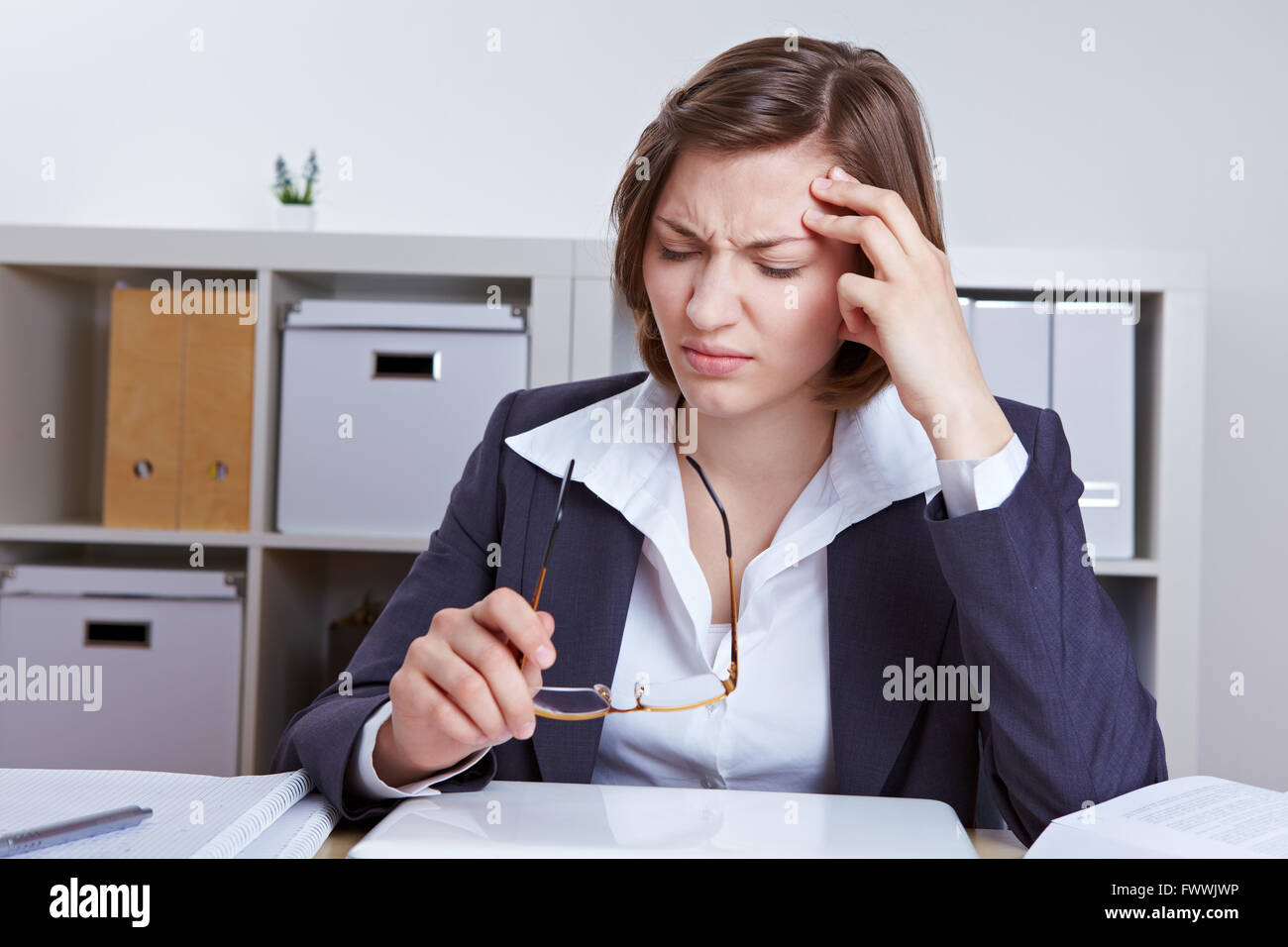 Business woman sitting with headache at her desk in the office Stock ...