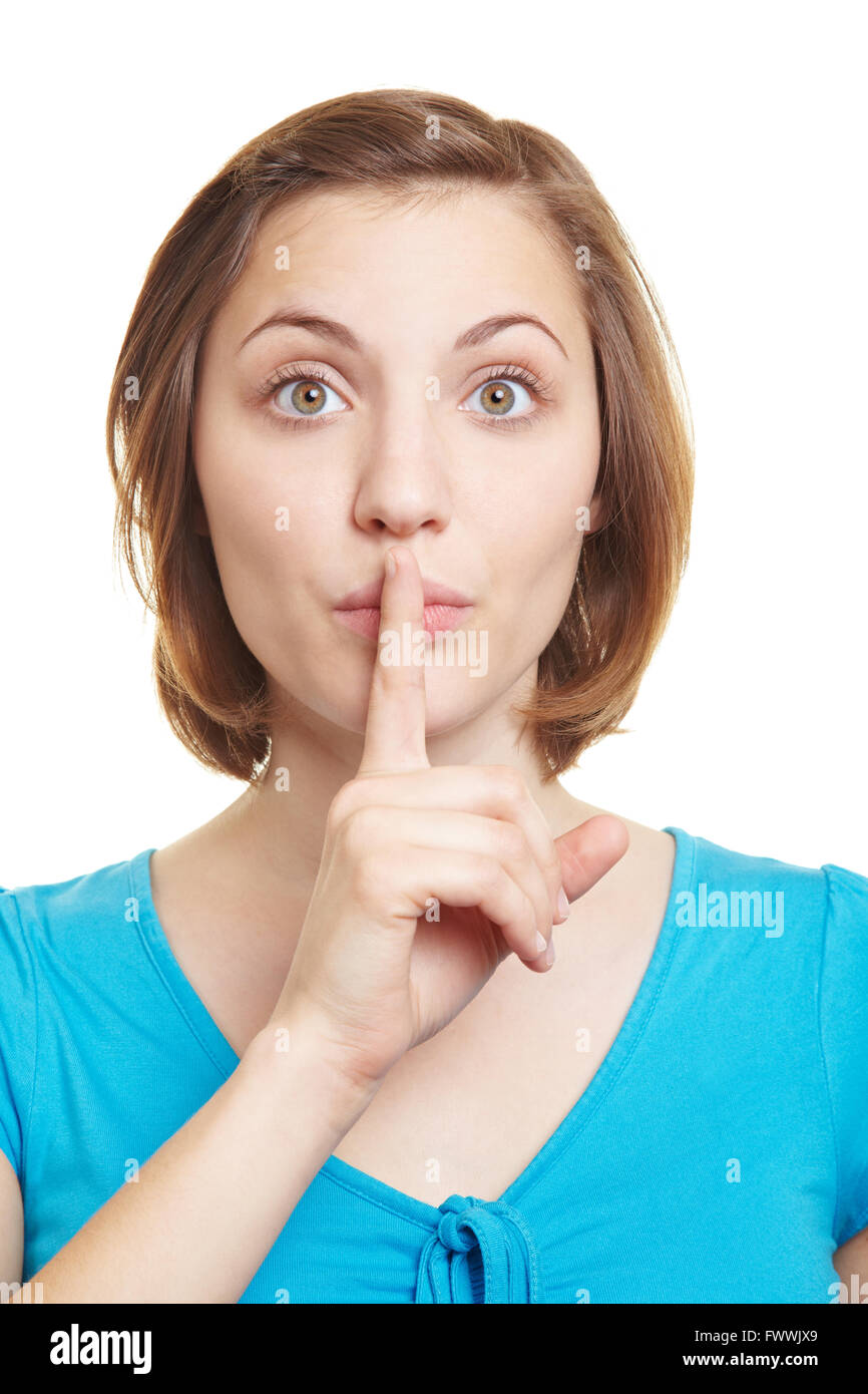Young woman holding her index finger in front of her mouth Stock Photo ...
