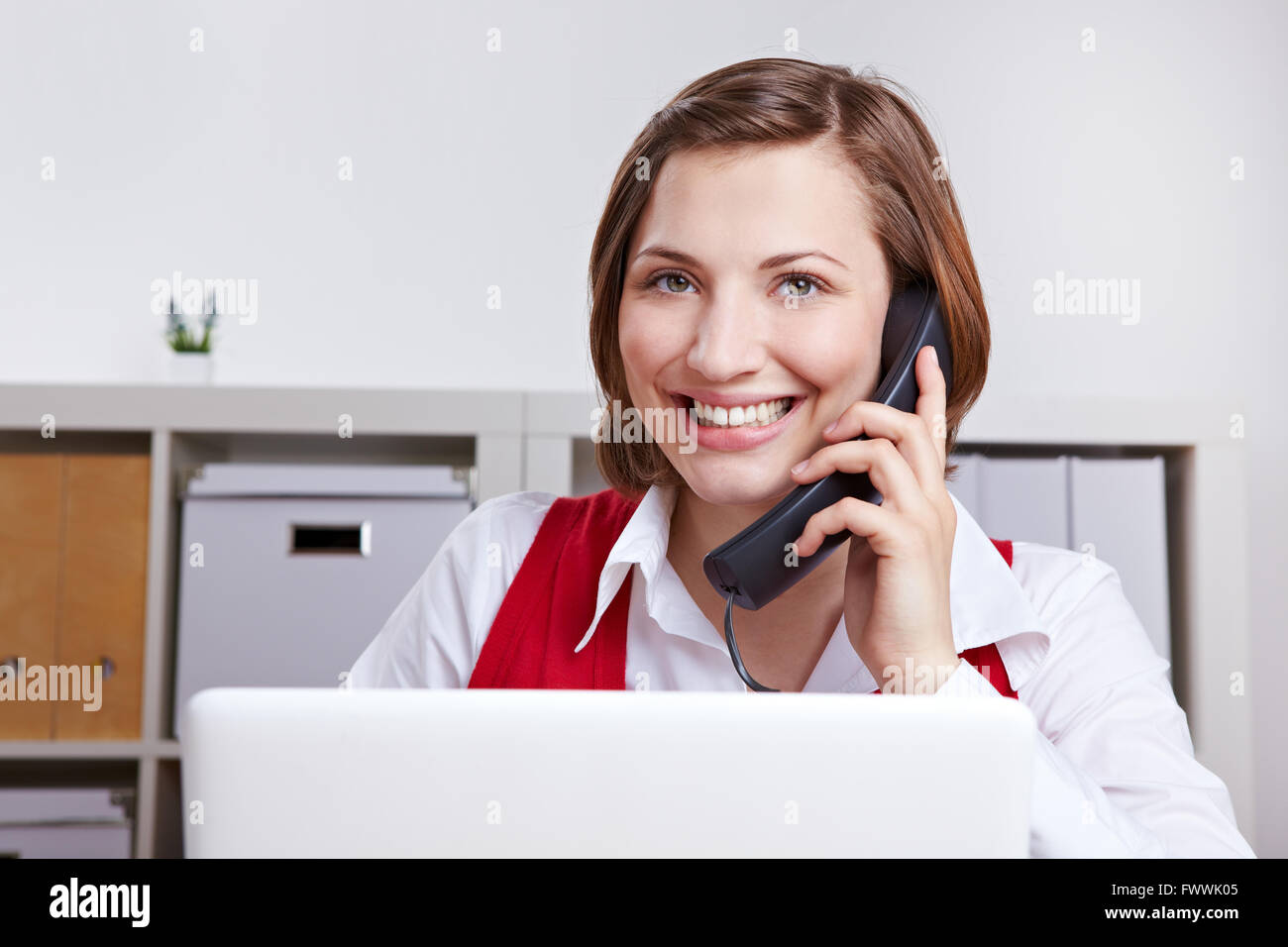 Happy woman in office calling the customer support hotline Stock Photo ...