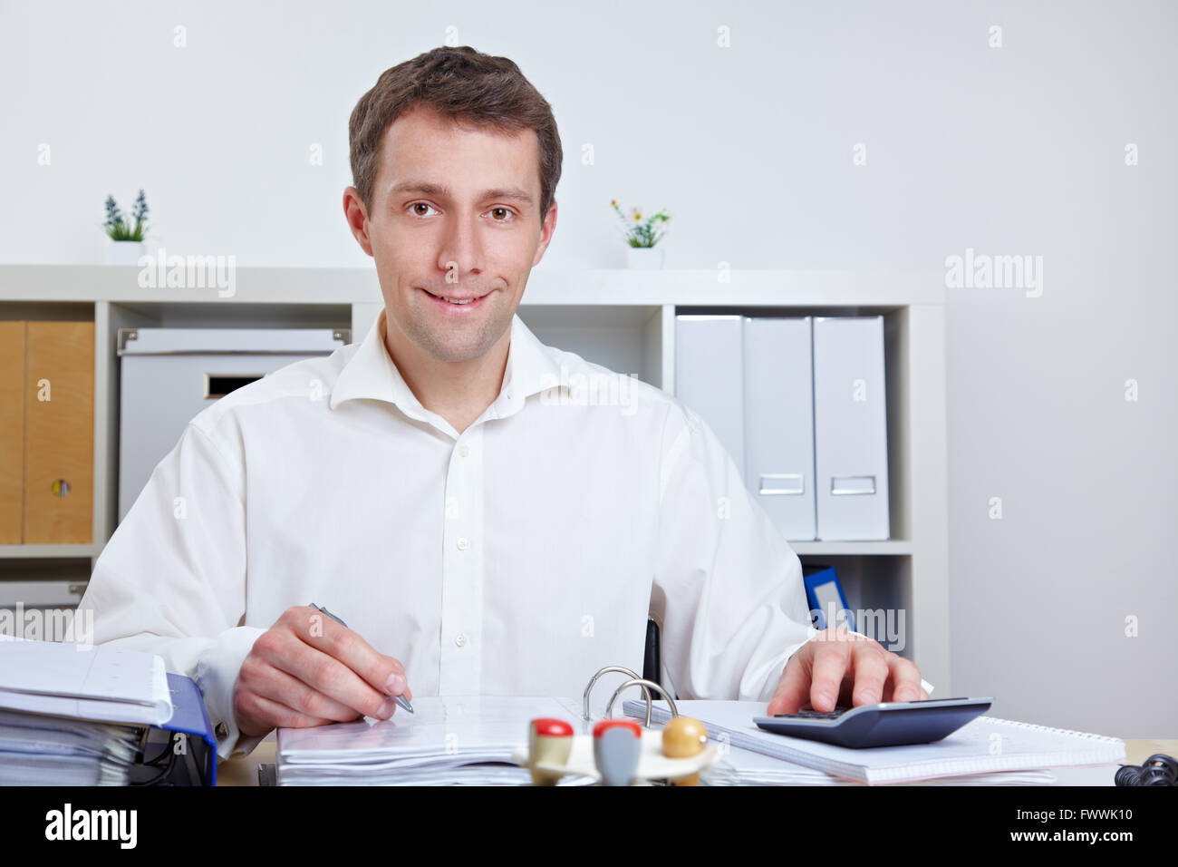 Smiling business man working at his desk in his office Stock Photo - Alamy