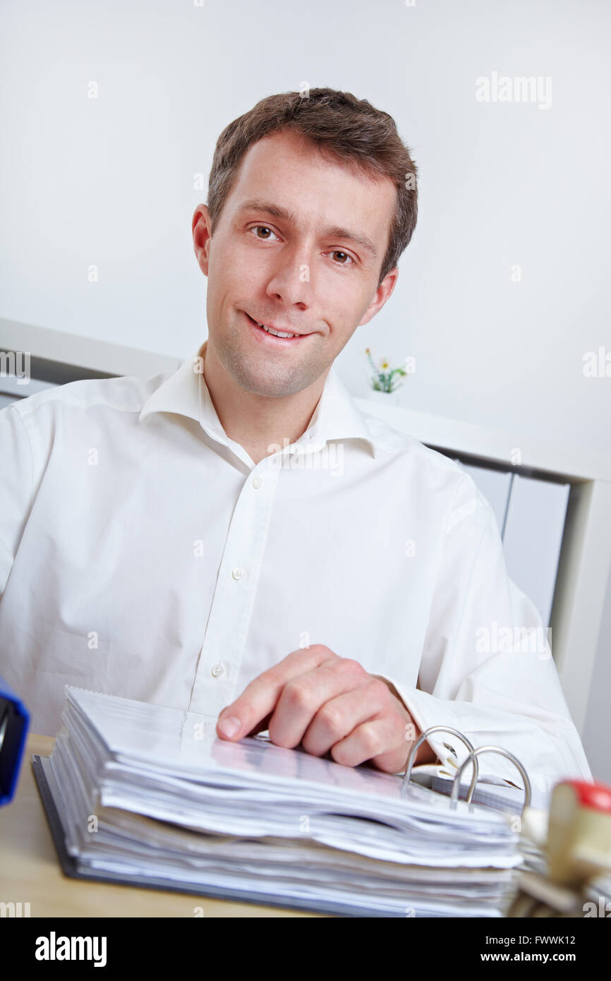 Smiling business man sitting at his desk in the office Stock Photo - Alamy