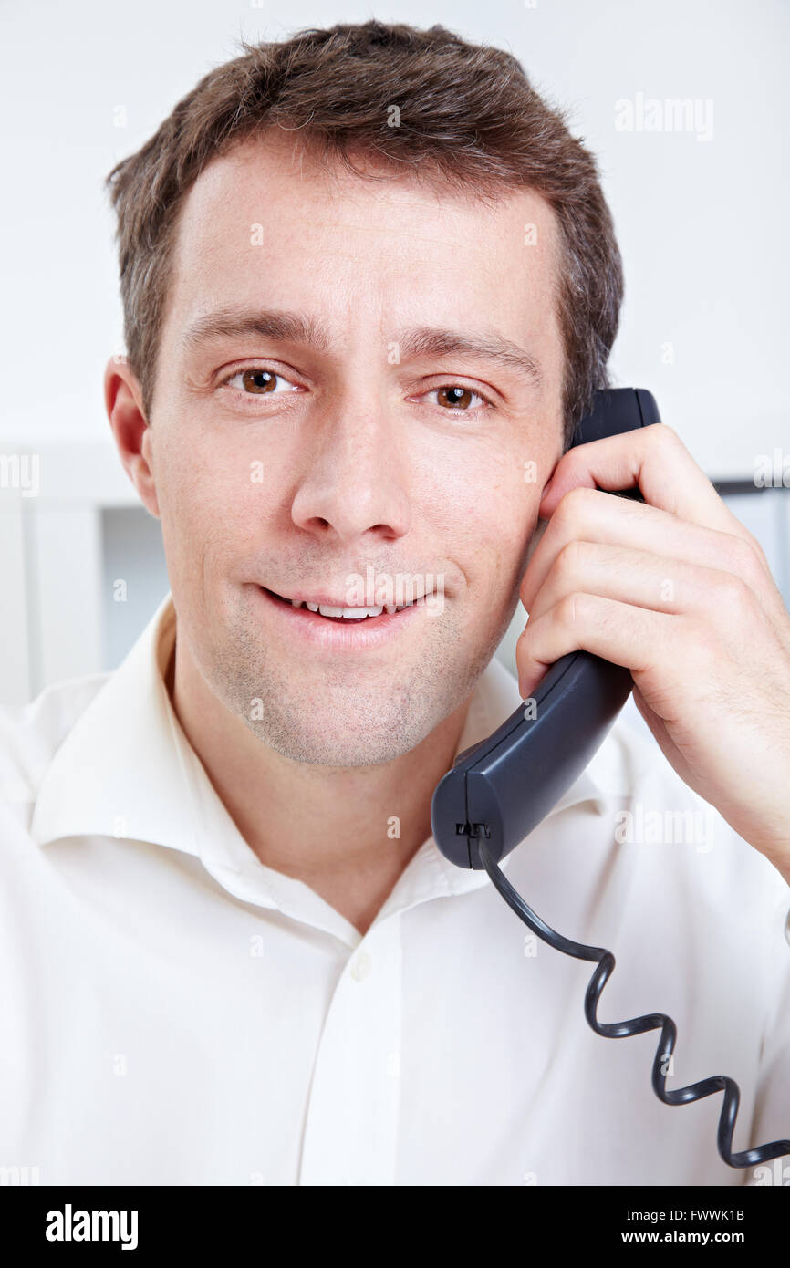 Smiling business man making phone call in the office Stock Photo - Alamy