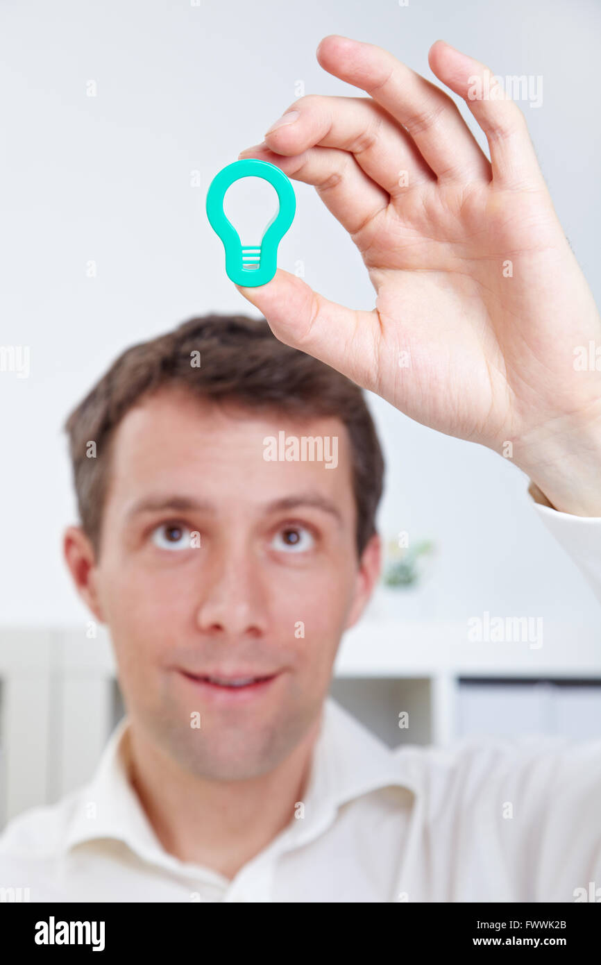 Smiling business manager holding lightbulb symbol over his head Stock ...