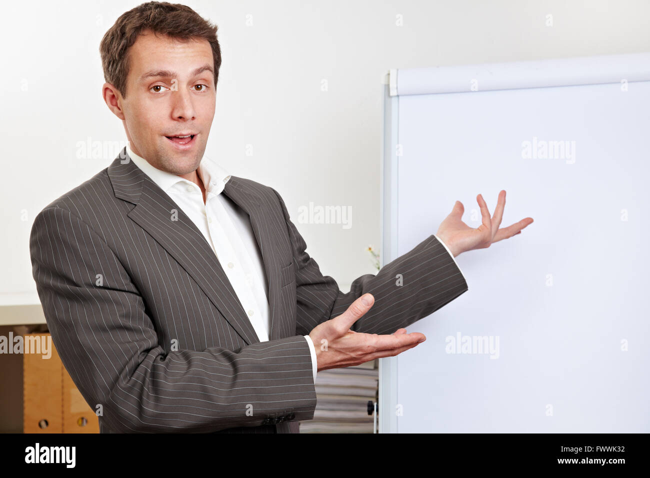 Business man during presentation pointing to white flipchart Stock ...