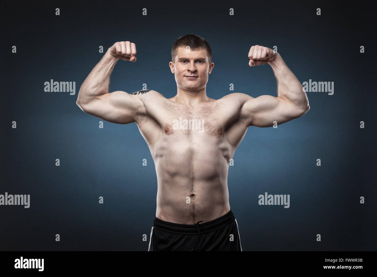 Sporty and healthy muscular man isolated on dark blue background Stock ...