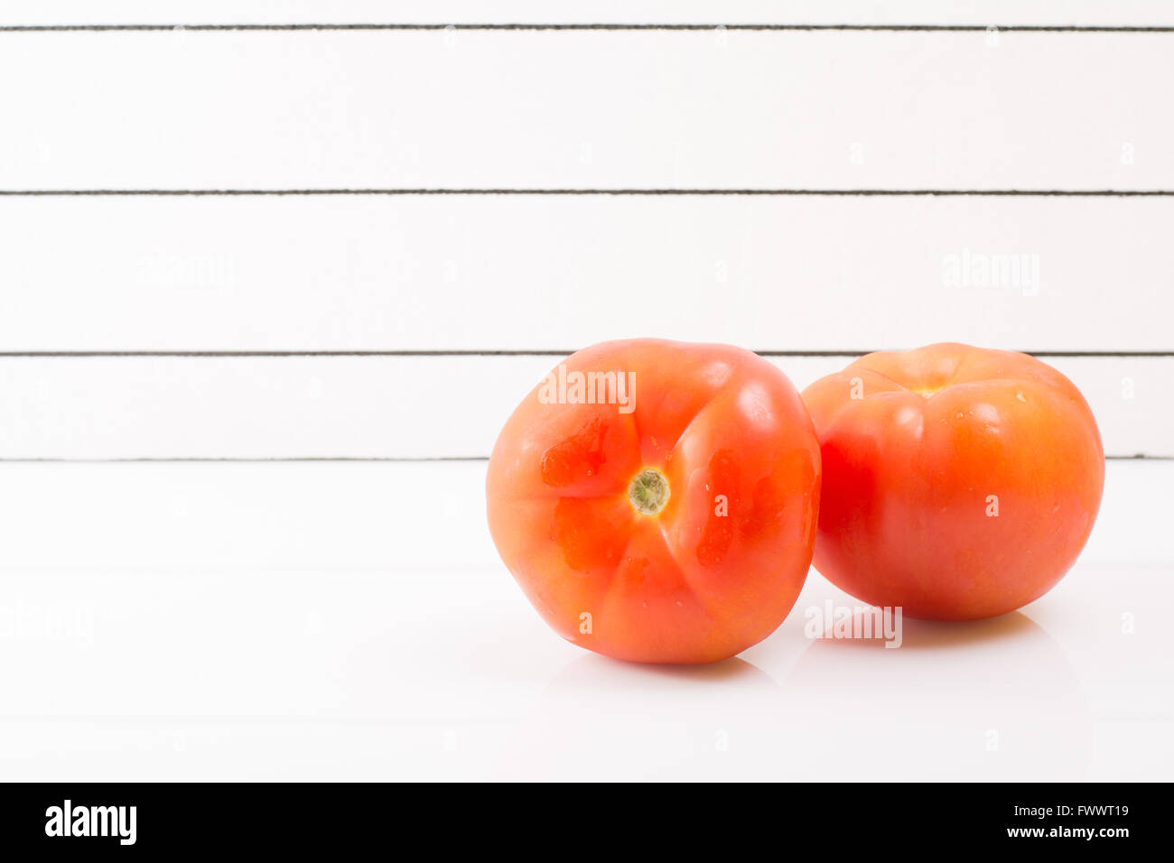 Two ripe tomatoes on a light background propped up Stock Photo - Alamy