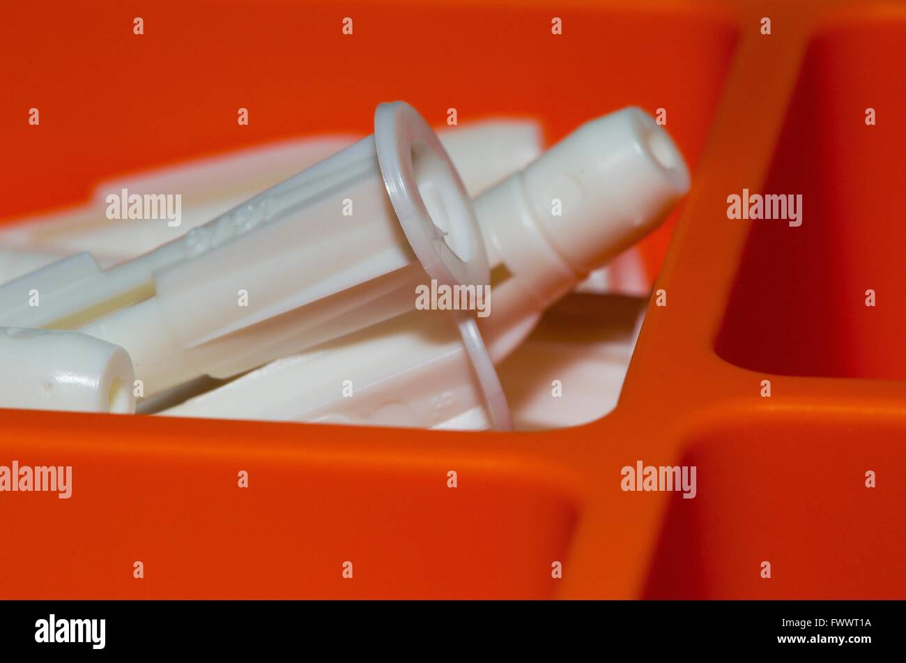 Several white industrial components in orange box Stock Photo - Alamy