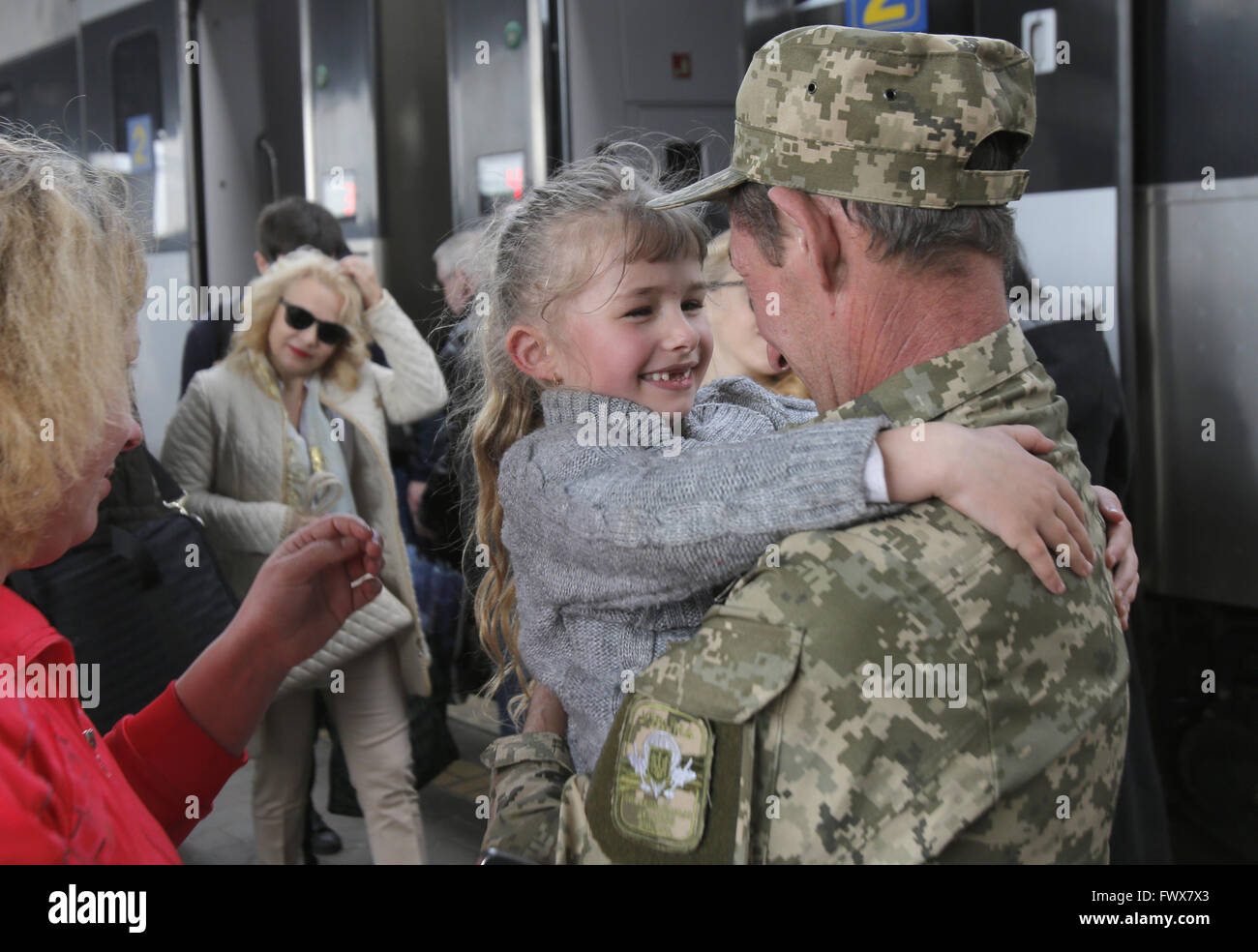 A Ukrainian serviceman hugs a child during a meeting at the railway ...