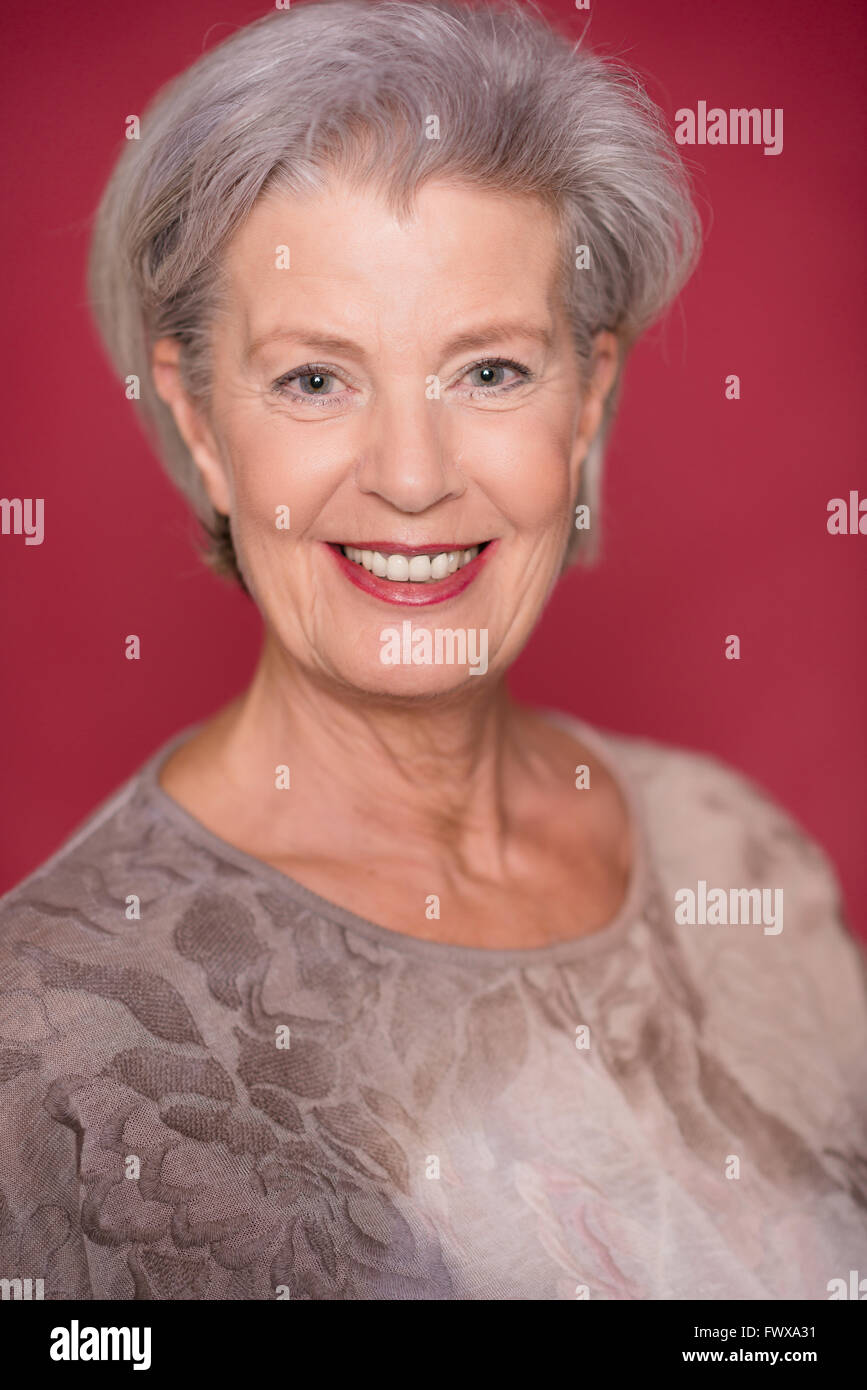 Happy seior woman in front of red background Stock Photo - Alamy