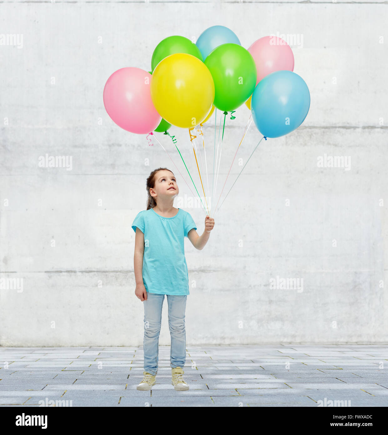 girl looking up with bunch of helium balloons Stock Photo - Alamy