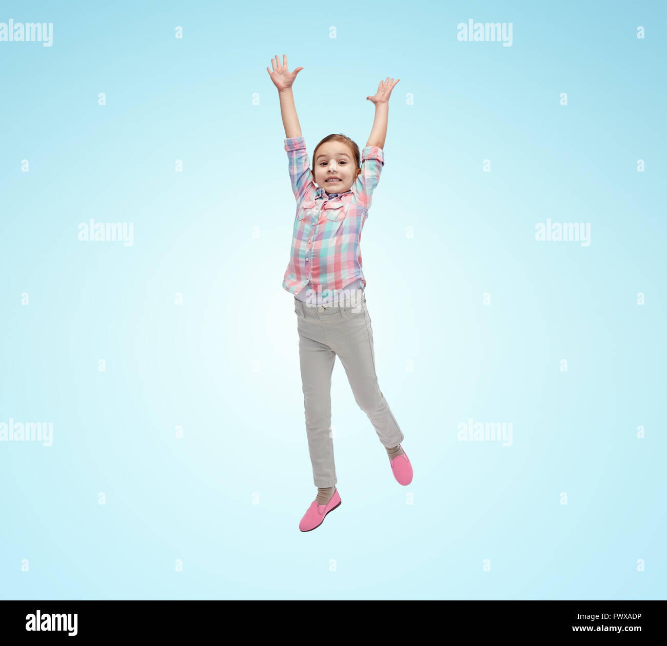 happy little girl jumping in air over blue Stock Photo - Alamy