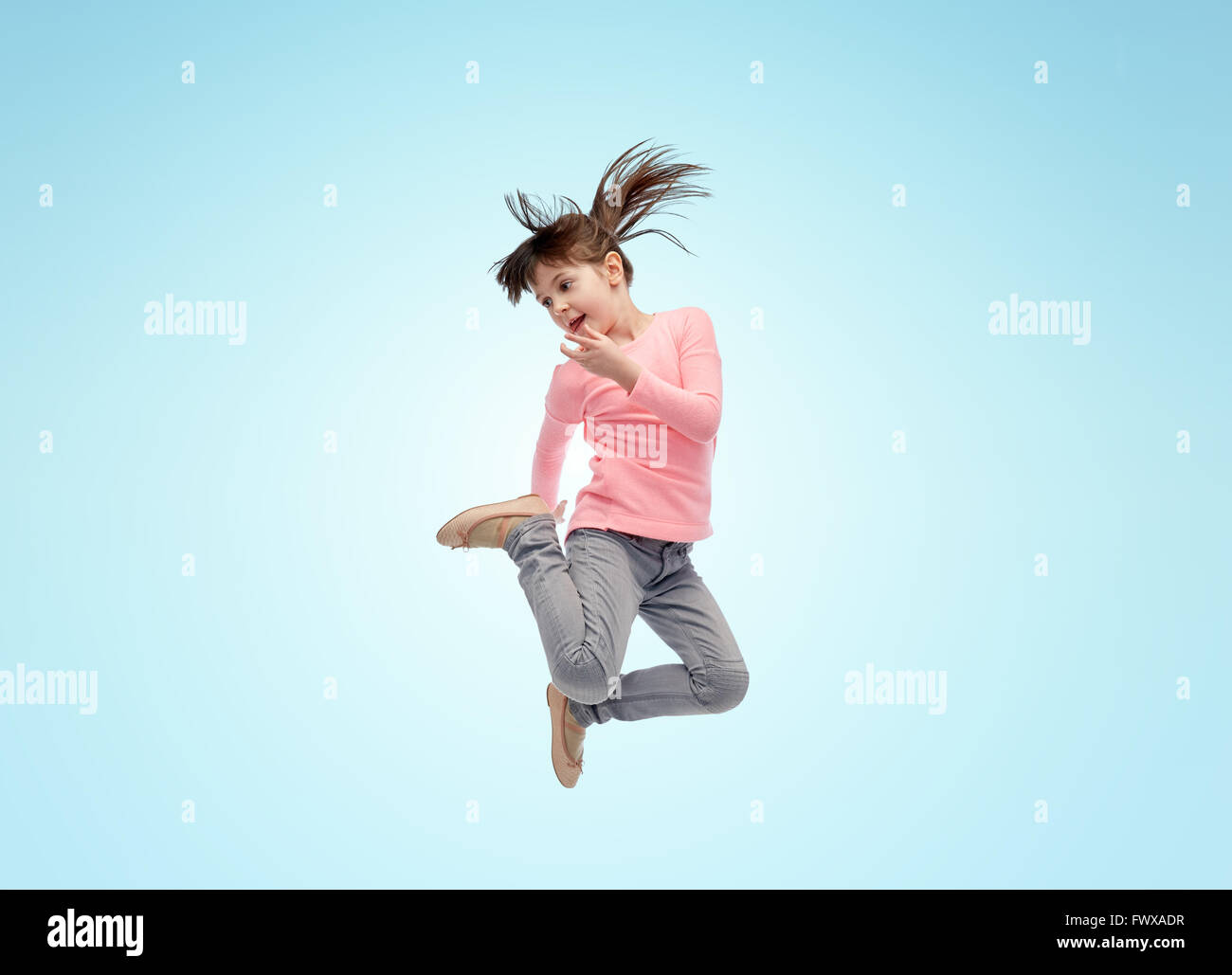 happy little girl jumping in air over blue Stock Photo - Alamy