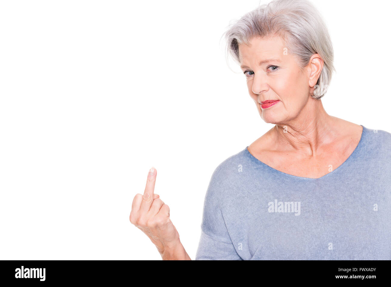 Senior woman gives someone the bird in front of white background Stock ...