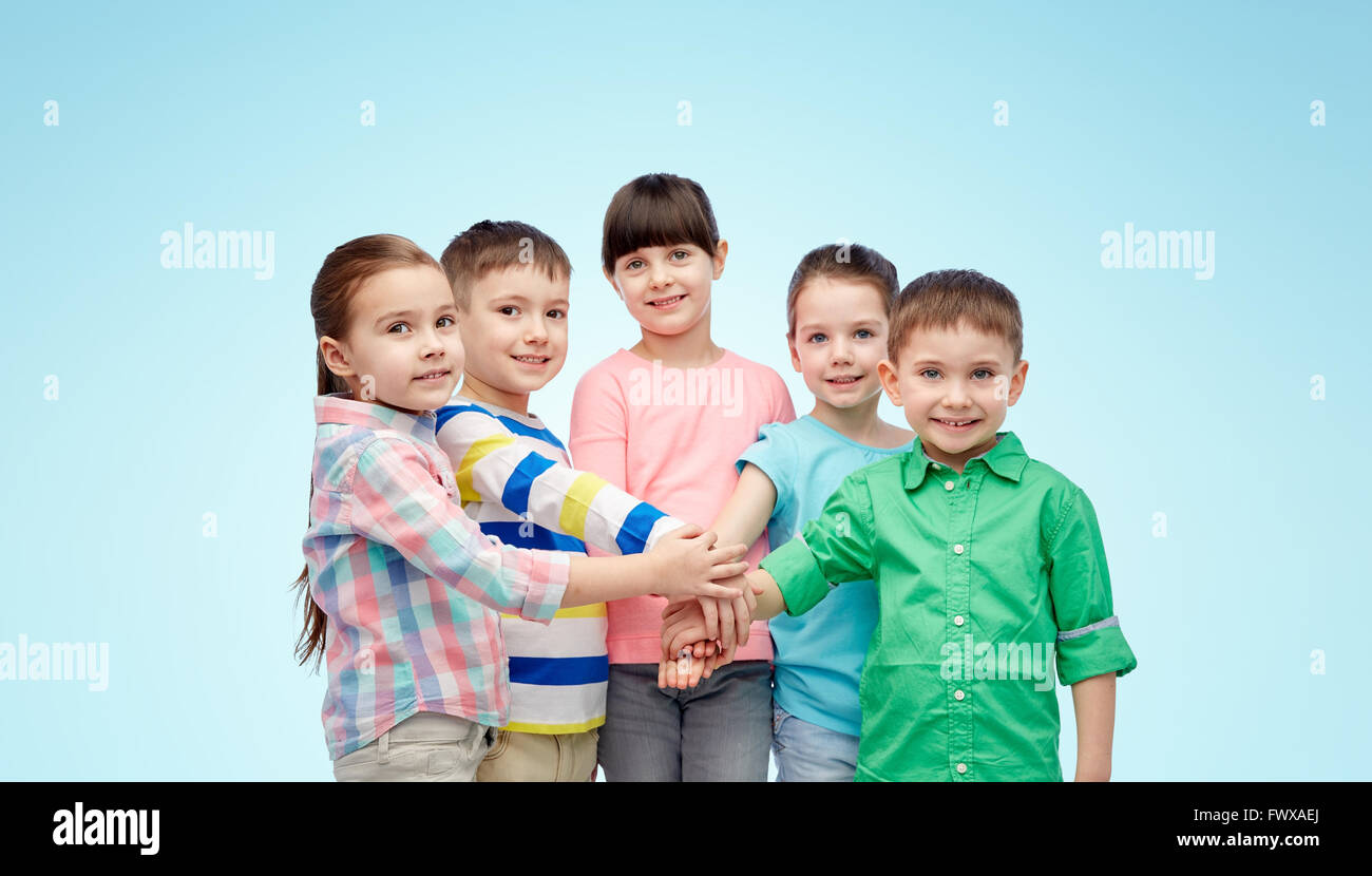 happy little children with hands on top over blue Stock Photo - Alamy