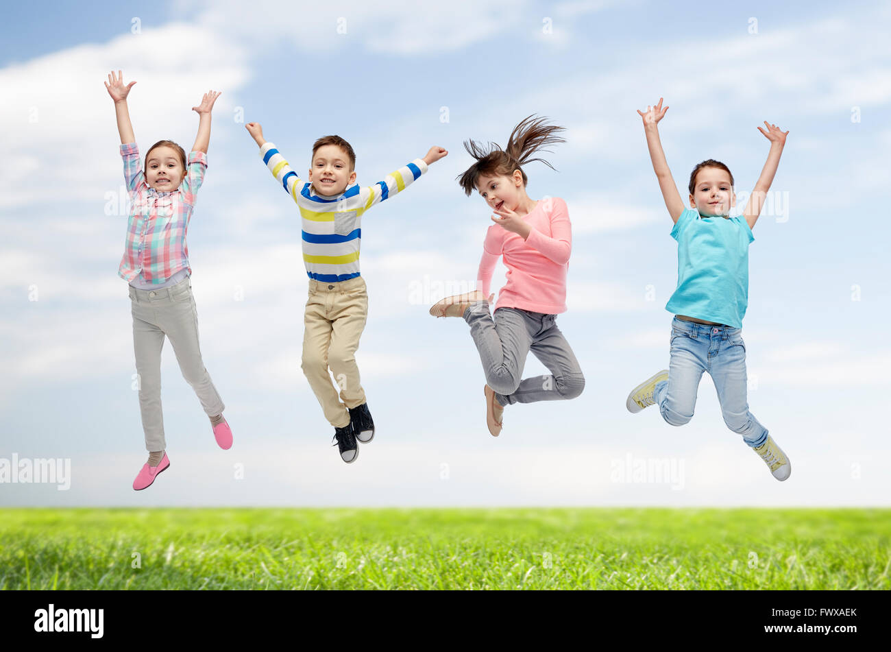 happy children jumping in air over sky and grass Stock Photo - Alamy