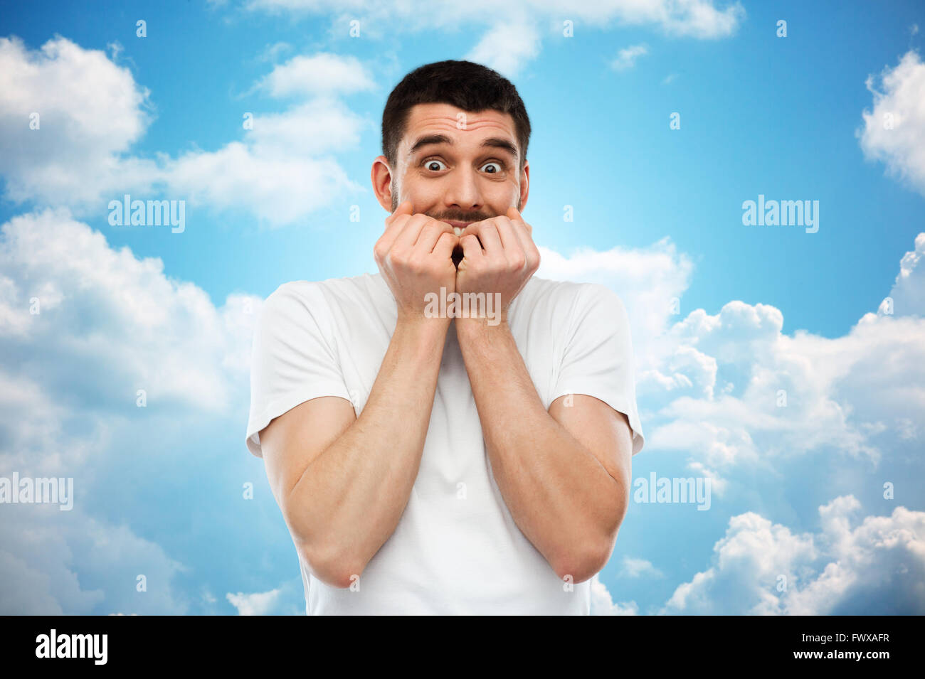 scared man in t-shirt over blue sky background Stock Photo - Alamy