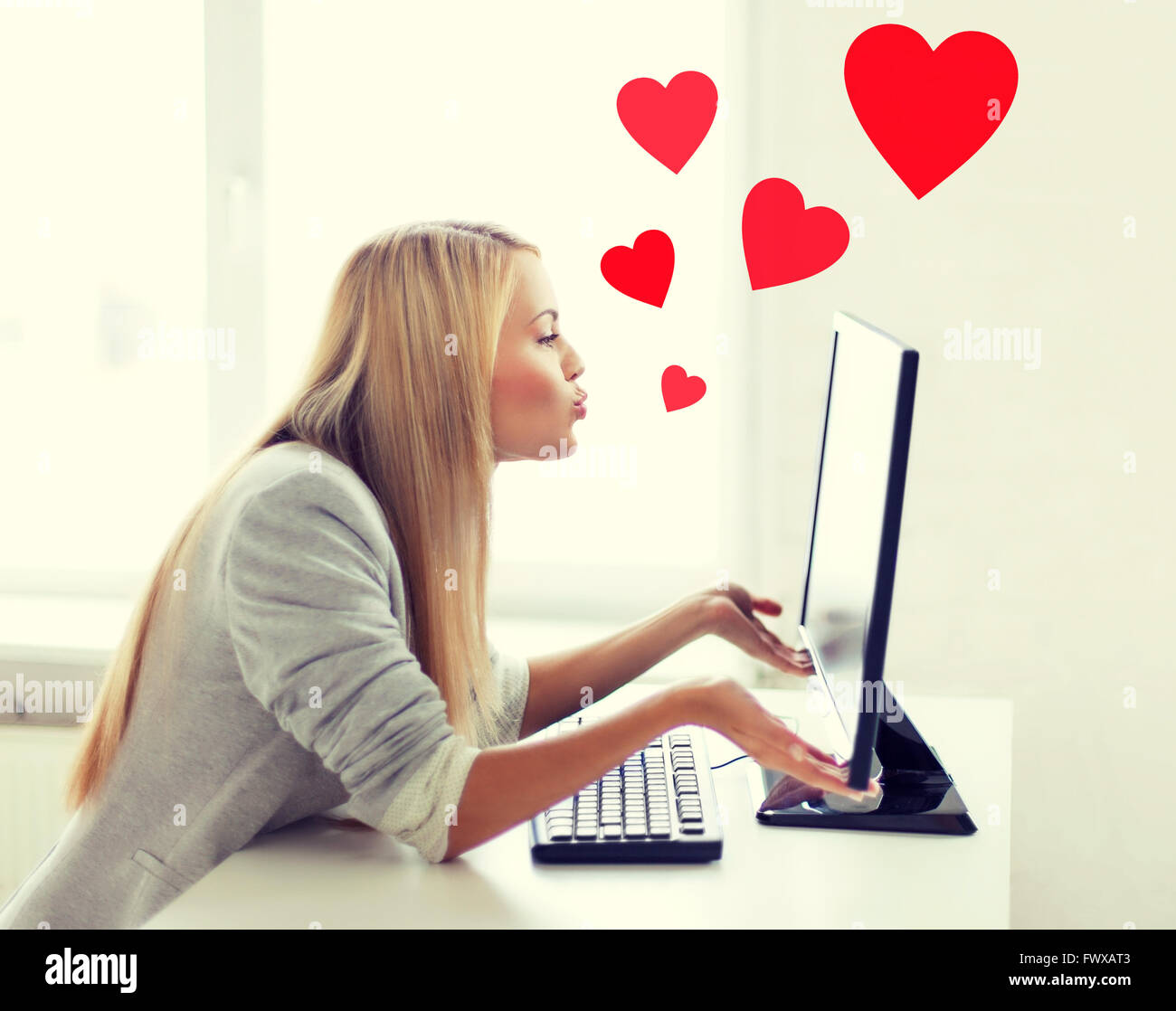 woman sending kisses with computer monitor Stock Photo - Alamy