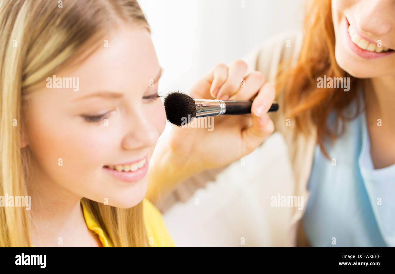 happy women with makeup brush applying blush Stock Photo - Alamy