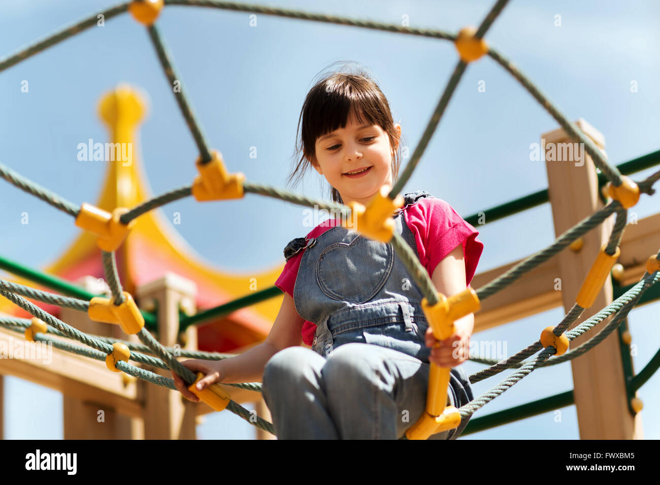 happy little girl climbing on children playground Stock Photo - Alamy