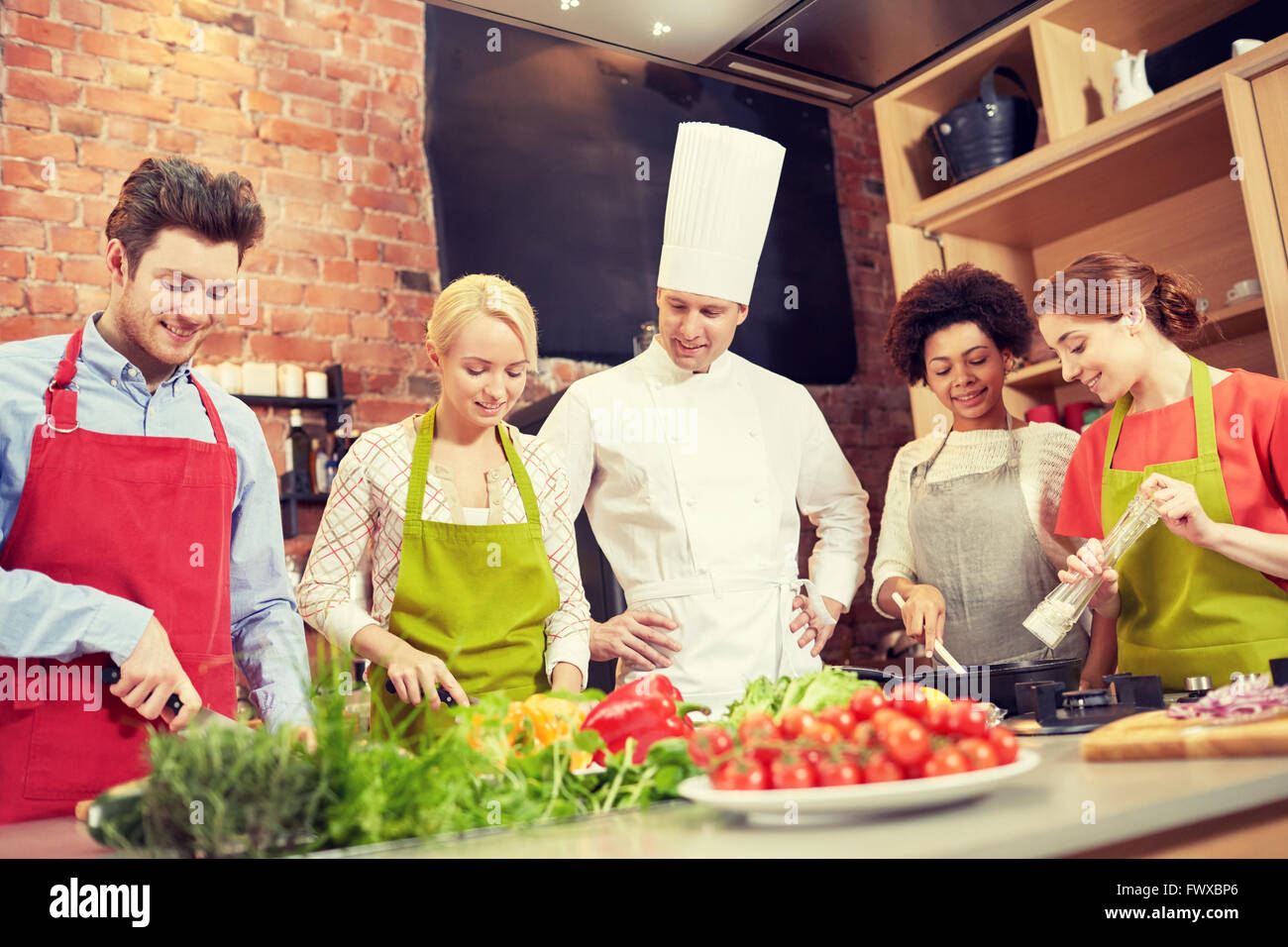 happy friends and chef cook cooking in kitchen Stock Photo - Alamy