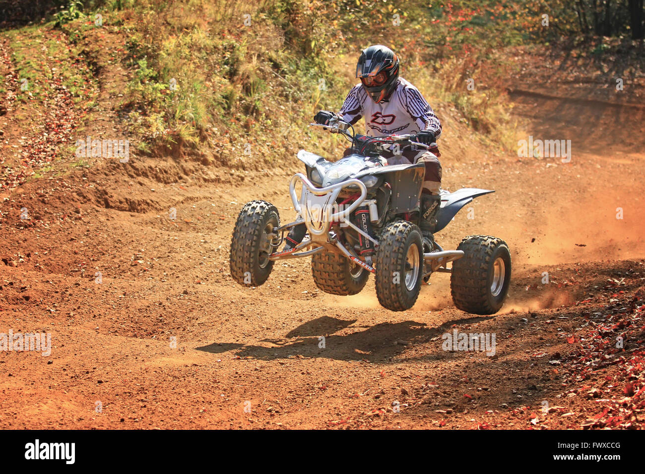 Racer rides a quad motorbike in difficult terrain Stock Photo - Alamy