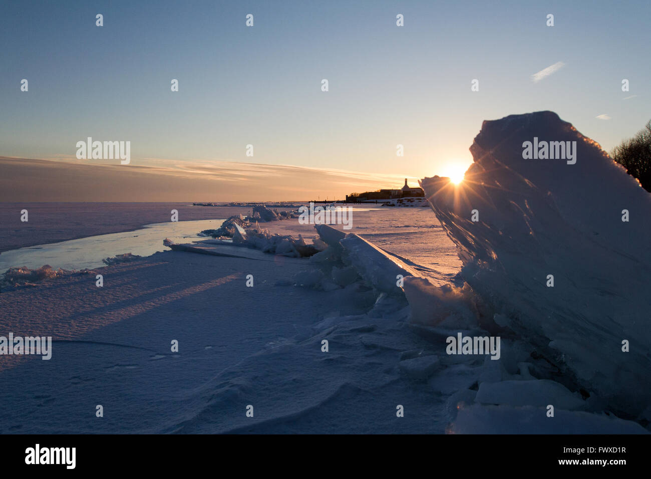 The sun sets behind an ice ridge on Lake Ontario in Kingston, Ont., on ...