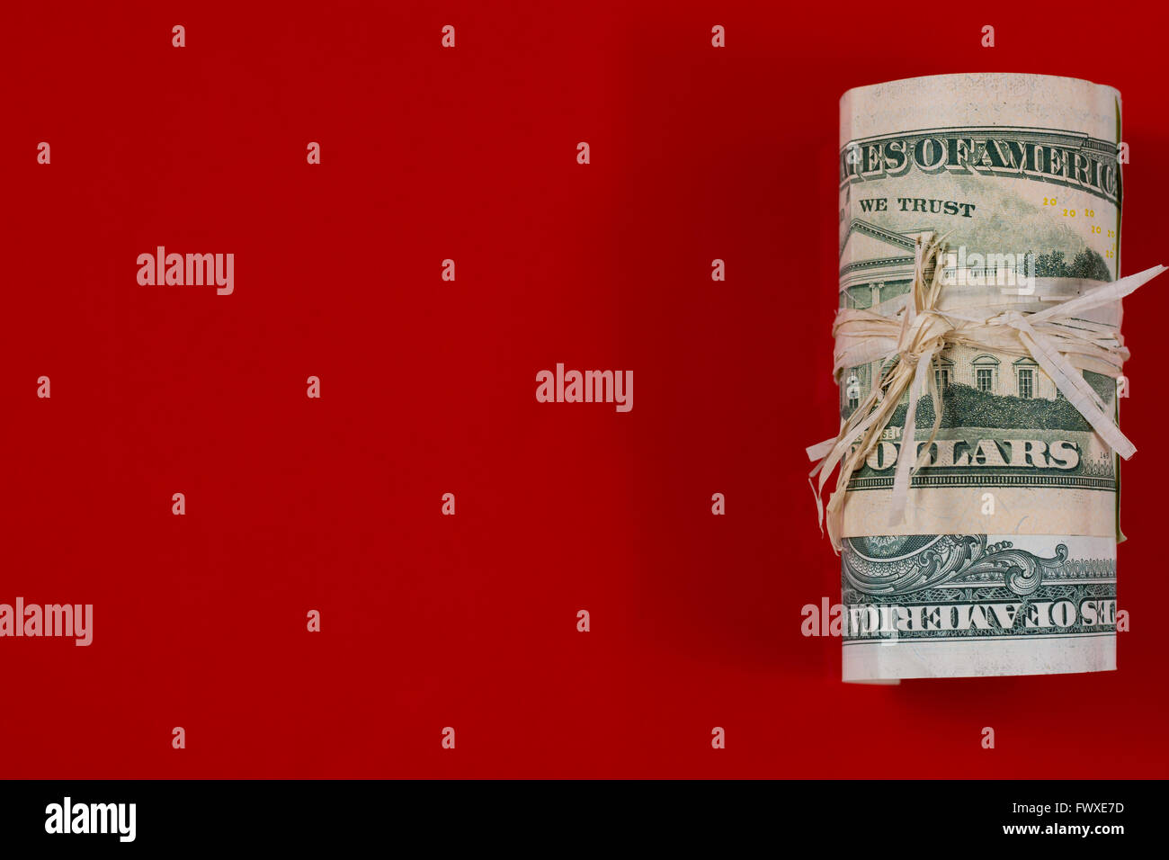 US dollars cash roll on red background Stock Photo - Alamy