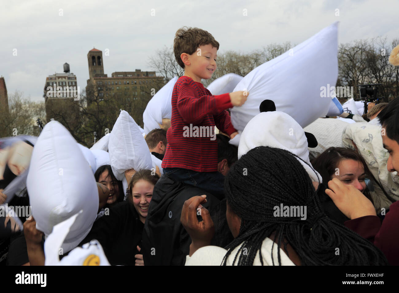 A young boy pillow fighting with others in International Pillow Fight ...