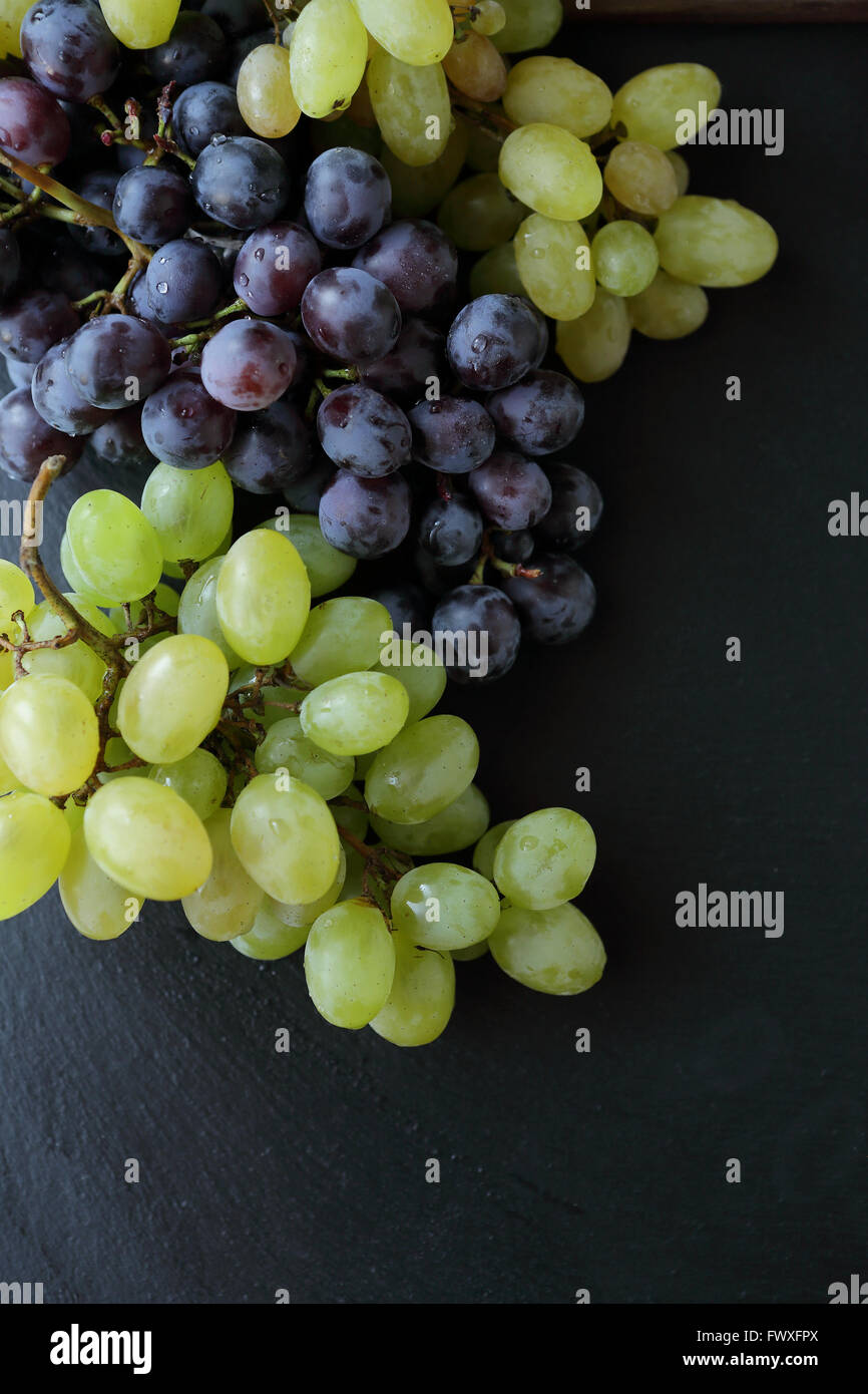 two branches of grapes on slate background Stock Photo - Alamy